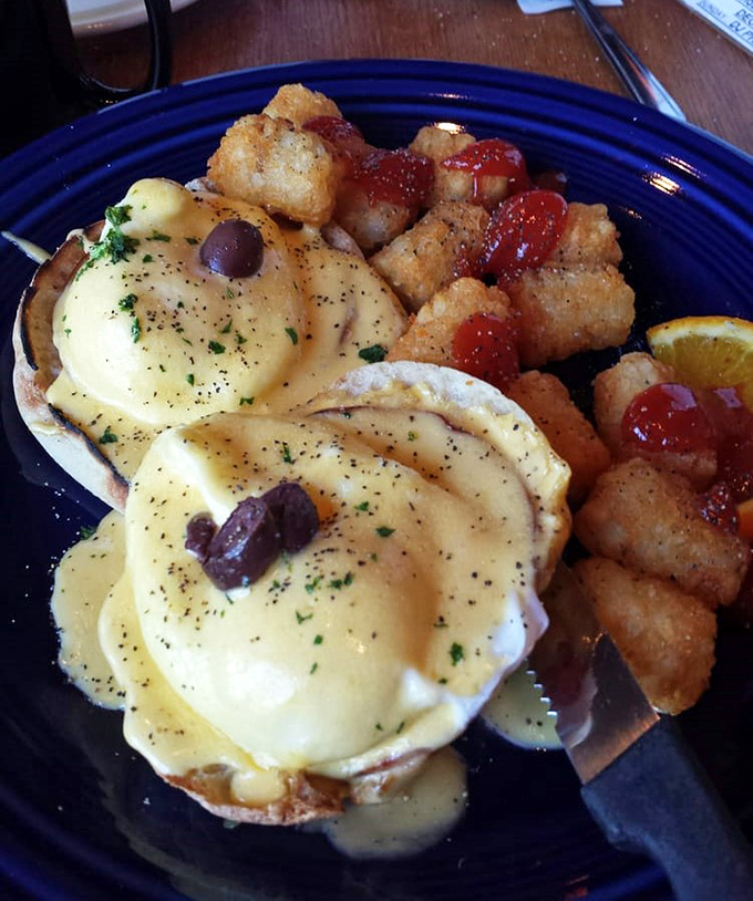 Behold the holy grail of breakfast: eggs benedict with hollandaise cascading like a golden waterfall over perfectly poached eggs. Those home fries aren't just sidekicks&mdash;they're co-stars.