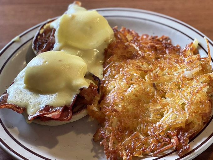 Behold, the star of our show! Eggs Benedict with hollandaise so velvety it should require a fashion credit, paired with hash browns that achieve the perfect crisp-to-tender ratio.