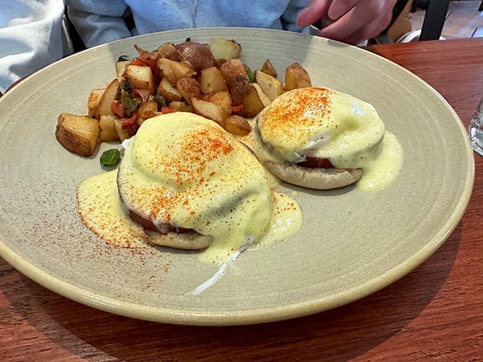 Eggs Benedict so perfectly executed, the hollandaise sauce cascades down like a yellow waterfall of buttery bliss.