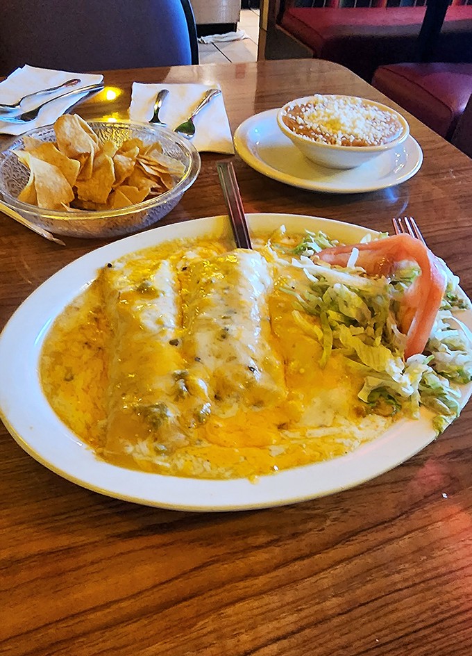 Enchiladas swimming in golden cheese sauce that would make King Midas jealous. That little side salad is just pretending you're making a healthy choice.