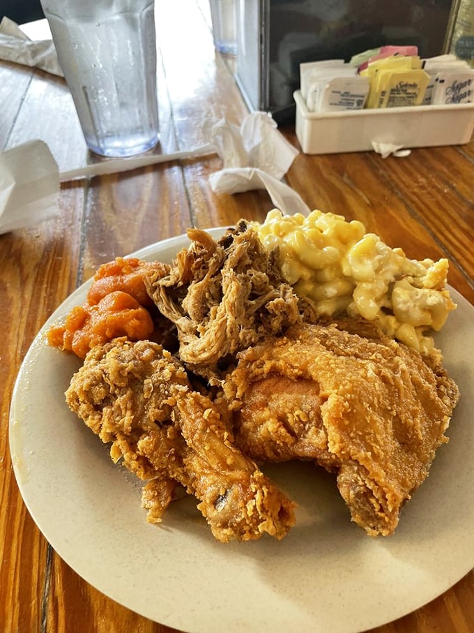 Golden-crusted fried chicken alongside creamy mac and cheese and sweet yams &ndash; the holy trinity of Southern comfort on a single plate.