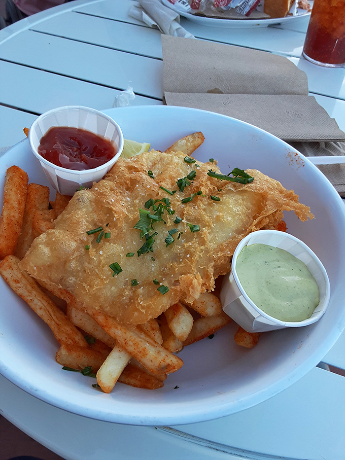 Golden-battered fish that shatters like glass revealing steamy, flaky perfection within. This isn't just fish and chips &ndash; it's edible poetry.