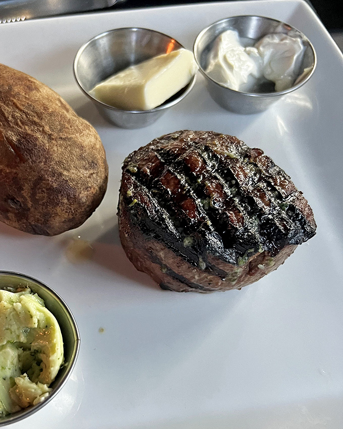 Behold the star of the show&mdash;a perfectly grilled filet mignon with textbook grill marks, accompanied by a baked potato and sides that know their supporting role.