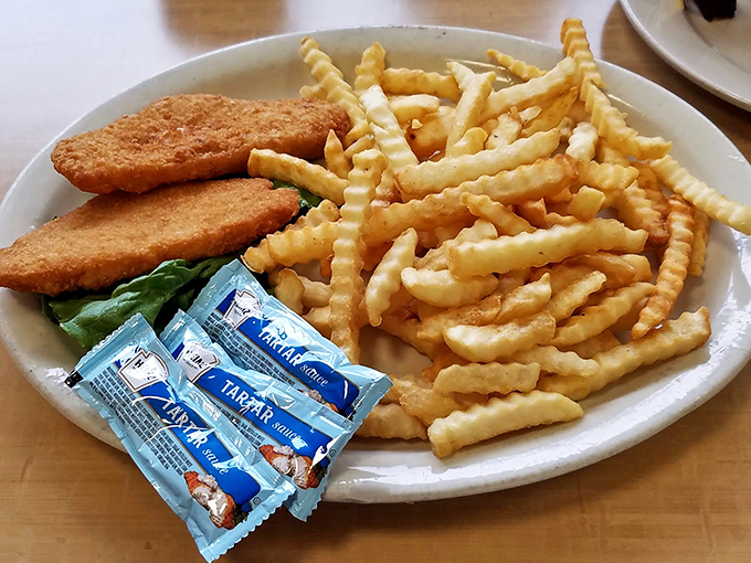 Fish so crispy it practically shatters at the touch of a fork, paired with crinkle-cut fries that could make a French chef reconsider their life choices.