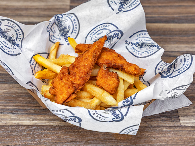 Golden-battered fish rests atop a bed of crispy fries, wrapped in branded paper – seafood's version of being dressed in its Sunday best.
