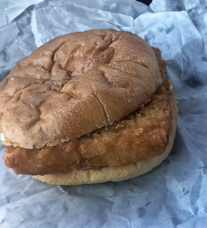 The star of our show: a perfectly golden fish sandwich that would make coastal seafood shacks jealous, nestled in wax paper like a crispy treasure.