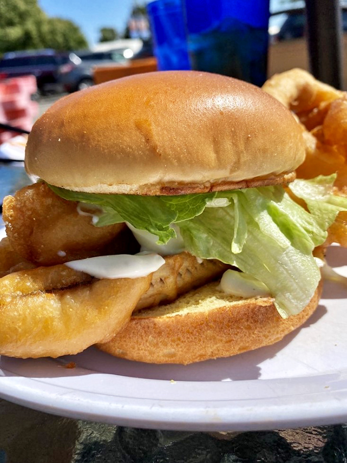Golden-fried perfection meets crisp lettuce on a pillowy bun. This fish sandwich isn't just lunch—it's the reason people drive hours across Michigan's peninsulas.