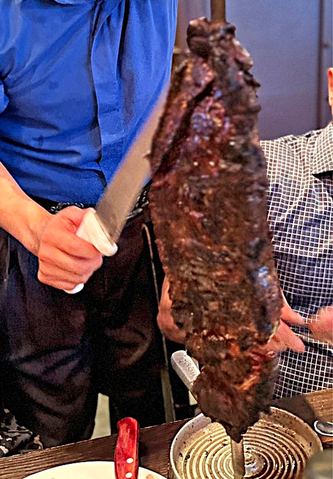 The gaucho slices the glistening flank steak with surgical precision. This isn't just dinner; it's performance art with delicious consequences.