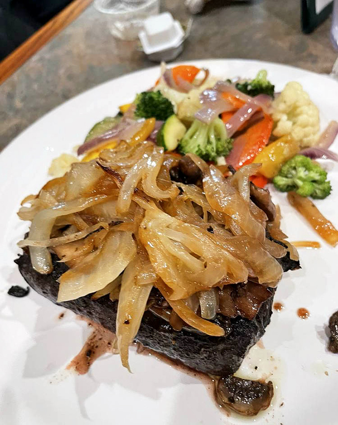 This flat iron steak topped with caramelized onions isn't trying to impress Instagram—it's too busy impressing your taste buds.
