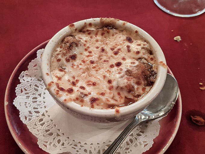 Behold the French onion soup that launched a thousand return visits, bubbling under its golden cheese crown.