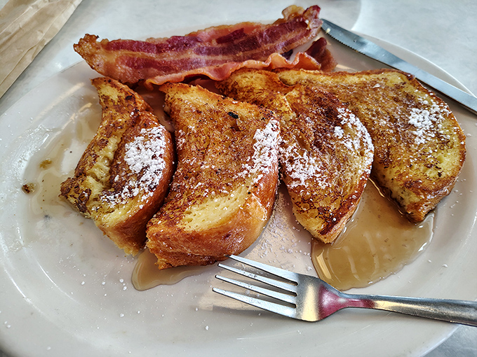 French toast that's achieved the impossible trifecta: crispy edges, custardy center, and enough maple syrup to make a Canadian blush with pride.