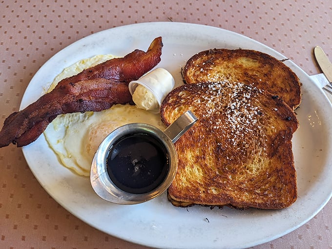 Two golden slices of French toast perfection arrive with bacon that could make a vegetarian reconsider their life choices.