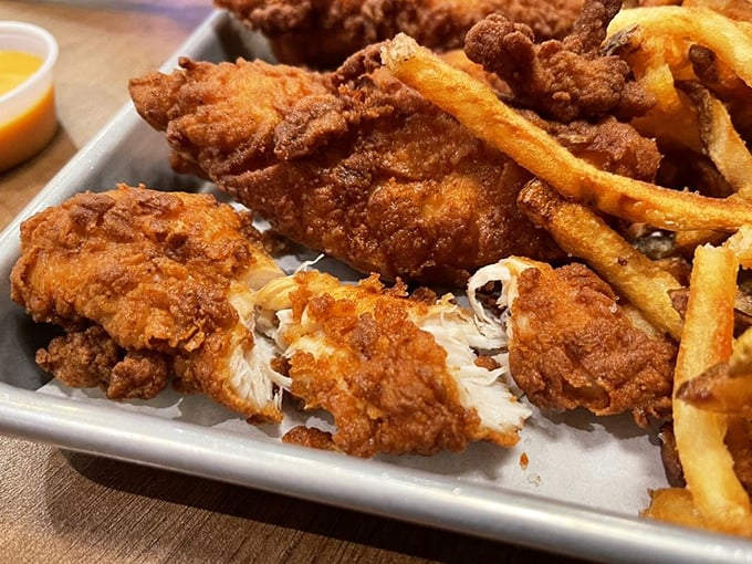 Behold the holy trinity of comfort food: golden-battered chicken, hand-cut fries, and a dipping sauce that's practically begging for your attention.