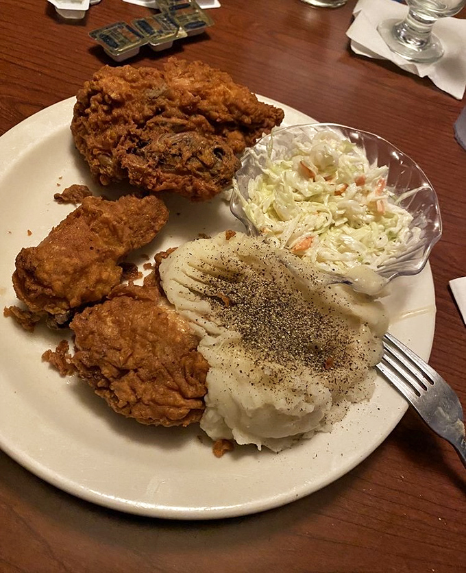 Fried chicken that crackles with golden perfection, served with mashed potatoes so creamy they make clouds jealous and coleslaw for that essential crunch.