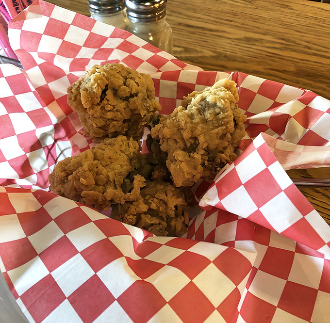 Golden-brown spheres of happiness nestled in a checkered basket. These aren't just fried mushrooms; they're Tennessee's edible treasures.