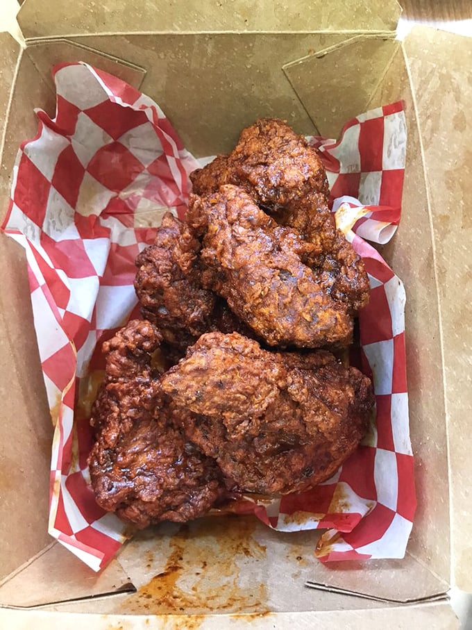 Golden-brown perfection nestled in a humble cardboard box. This isn't just fried chicken&mdash;it's edible artwork with a PhD in crunchology.
