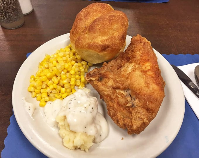 The holy trinity of comfort food: golden fried chicken, creamy mashed potatoes with gravy, and sweet corn&mdash;plus a roll that's begging to be buttered.