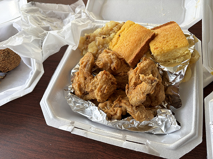 That golden-brown fried chicken arrives like a gift from the soul food gods, crispy perfection in a foam container.