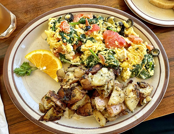 The legendary Greek Scramble in its natural habitat&mdash;bright yellow eggs mingling with spinach and feta, while those home fries play the perfect supporting role.