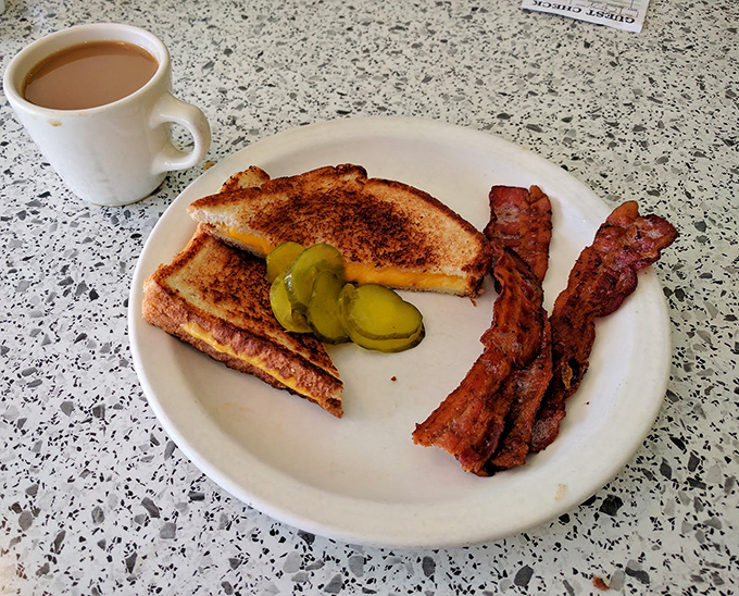 A perfect diner trifecta: golden grilled cheese, crispy bacon, and dill pickle slices that add just the right tangy crunch.