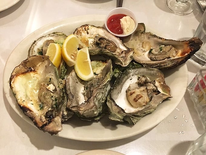 The legendary grilled oysters arrive with perfect char marks and a hint of lemon. One bite and you'll understand why people make pilgrimages here.