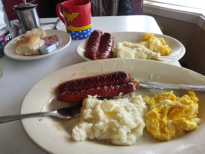 Sausage links with grits and eggs&mdash;a breakfast trinity that proves some culinary equations need no solving. That Wonder Woman mug isn't just for show.
