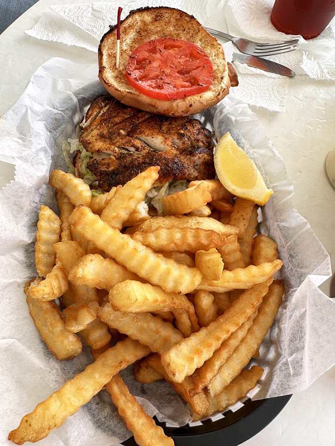 Not just a sandwich, but a seafood sermon&mdash;blackened grouper nestled between toasted bun with crispy fries standing guard.