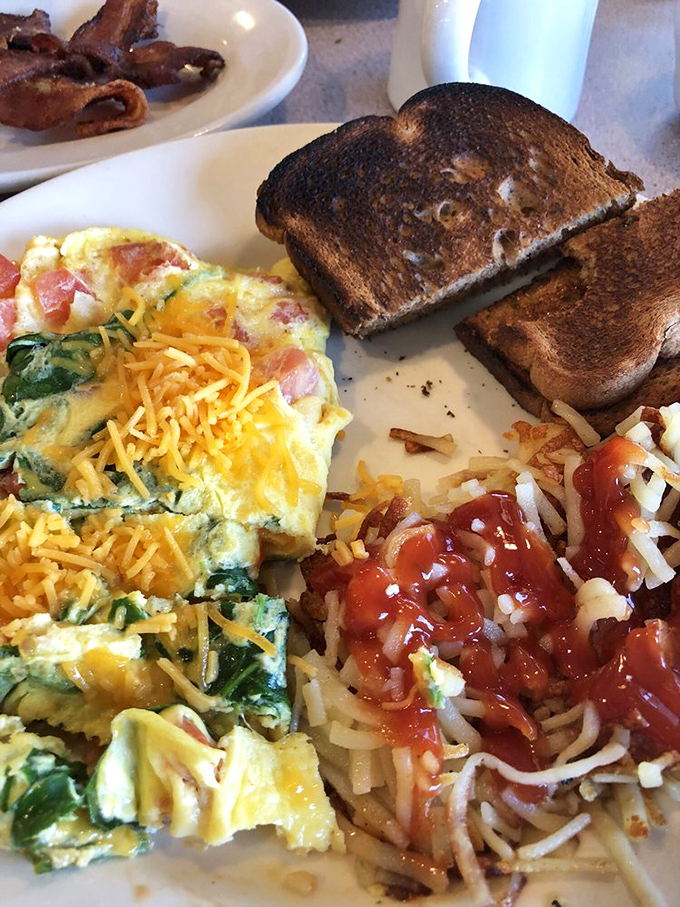 Behold the star attraction: an omelet that achieves the perfect cheese pull while spinach and tomatoes sneak in just enough virtue to justify dessert later.