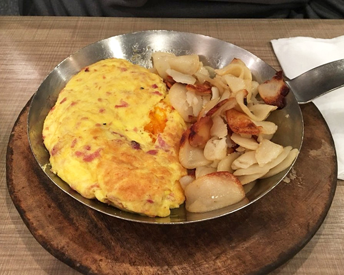 This isn't just an omelet; it's a masterclass in egg architecture with perfectly crisped potatoes standing guard alongside.