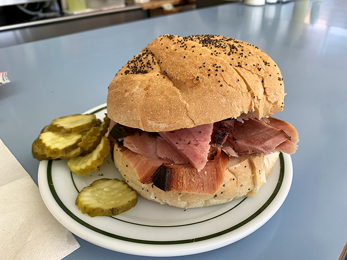 Behold the star of the show: ham piled generously on a poppy seed roll with pickle spears standing guard. Simplicity that would make minimalist architects weep with joy.