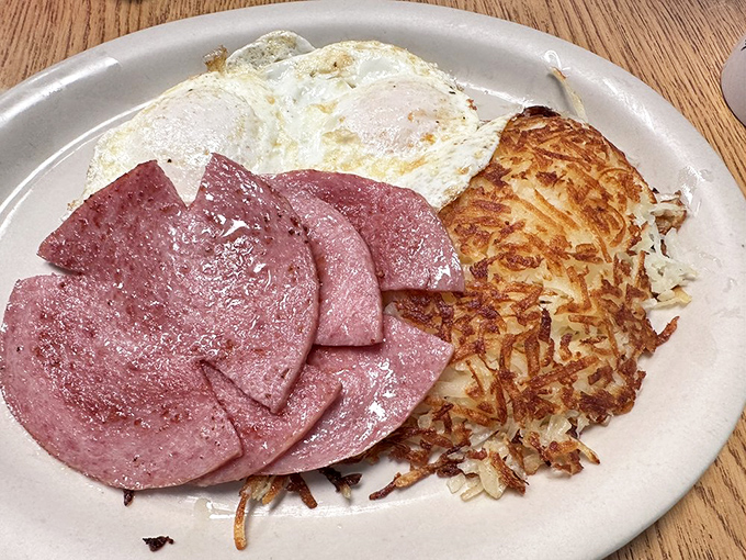 Breakfast simplicity at its finest: golden hash browns with the ideal crisp-to-tender ratio, eggs with sunshine-yellow yolks, and ham that means business.