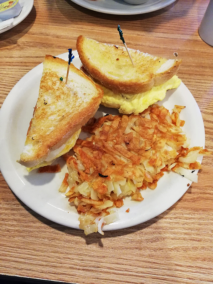 Golden-crisp hash browns sharing the plate with a perfectly toasted sandwich. This is the breakfast equivalent of finding front-row concert tickets in your coat pocket.