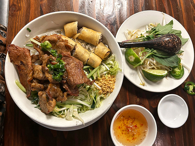A symphony of textures in one magnificent bowl. The crispy egg rolls and caramelized meat harmonize with fresh herbs like Sinatra and Bennett in their prime.