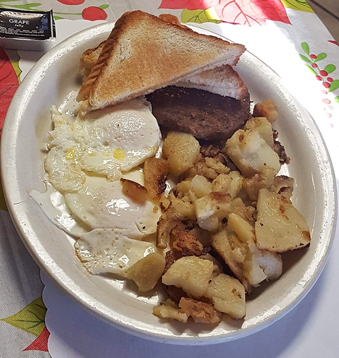 Breakfast perfection on a plate: golden home fries, eggs with just-right yolks, and a hamburger steak that means business.
