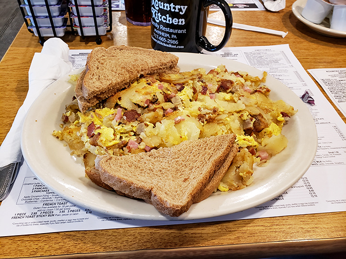 Behold the legendary home fries in their natural habitat! Crispy, golden chunks mingling with eggs and ham like old friends at a delicious reunion.