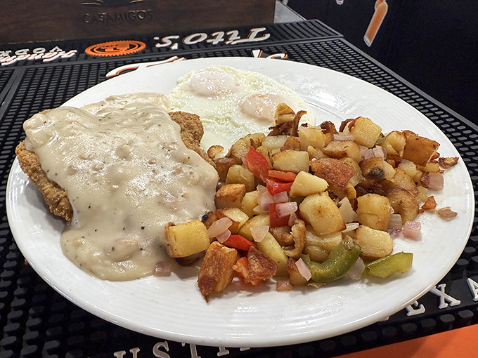Country-fried steak smothered in peppery gravy alongside crispy home fries and eggs &ndash; breakfast architecture that would make Frank Lloyd Wright weep with joy.