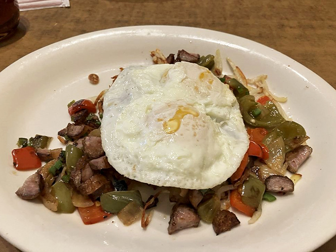 Breakfast hash perfection &ndash; crispy potatoes, colorful peppers, and savory meat topped with an egg that's sunny-side up in more ways than one.