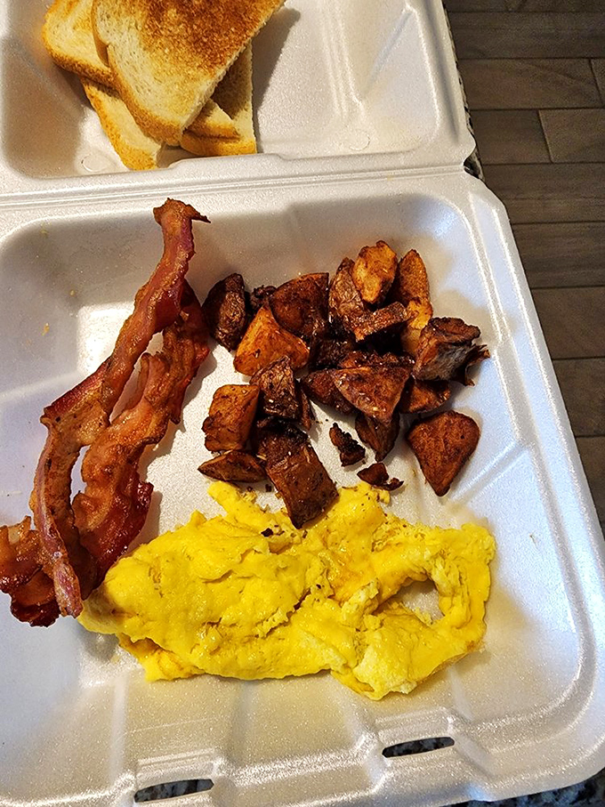 The breakfast trinity&mdash;golden eggs, crispy bacon, and potatoes that have clearly been on speaking terms with butter and salt. Simple perfection in a to-go container.