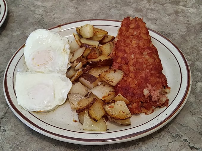 Eggs with perfect sunny-side-up centers alongside crispy hash browns and what might be the world's most perfect corned beef hash. Breakfast nirvana achieved.