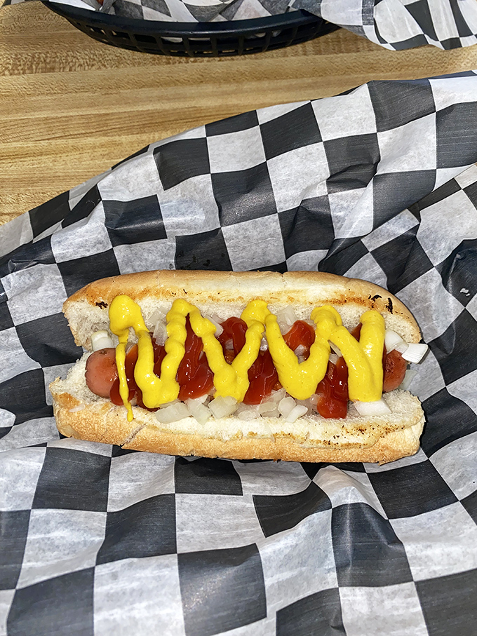 Hot dog perfection in its natural habitat&mdash;a checkered paper basket. That zigzag of mustard isn't just decoration, it's edible sunshine.