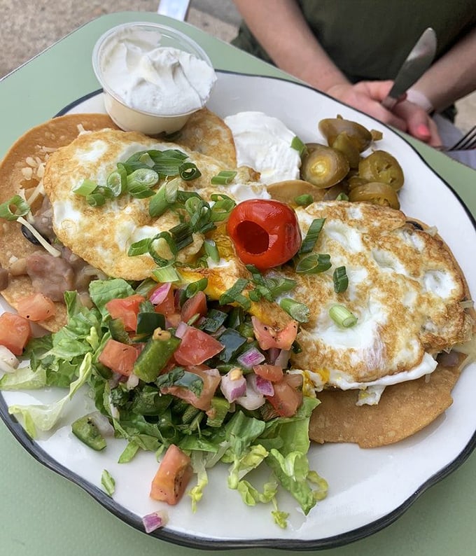Huevos Rancheros: where tortillas meet eggs in perfect harmony. Fresh pico, creamy sides, and pickled jalape&ntilde;os create a breakfast symphony.
