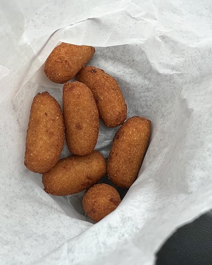 Golden-brown hush puppies that crackle when bitten, revealing a tender cornmeal interior that's the perfect vehicle for sopping up barbecue sauce.