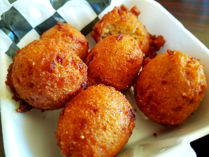 These golden hush puppies aren't just side dishes; they're crispy orbs of cornmeal perfection that disappear faster than your willpower.