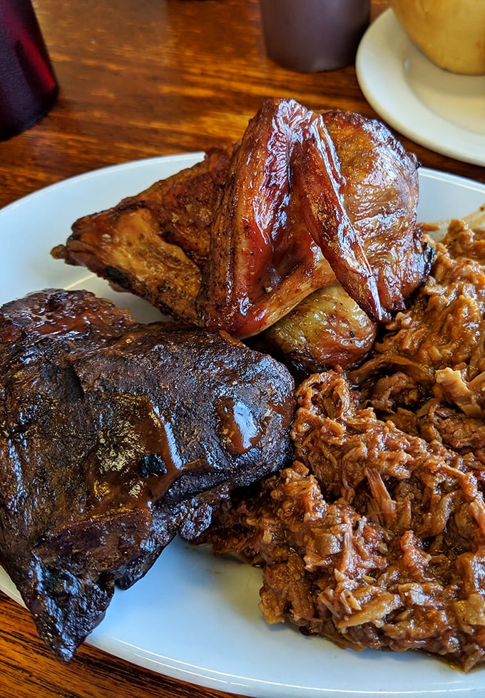 BBQ perfection on a plate: ribs with that telltale smoke ring, brisket with bark to die for, and pulled pork begging for your attention.