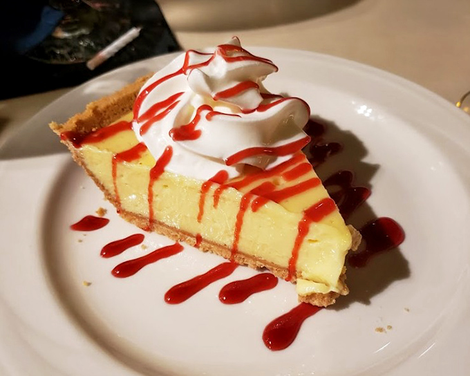 Key lime pie perfection: that pale yellow hue signals authenticity, while the raspberry drizzle adds a touch of drama worthy of a Florida sunset.