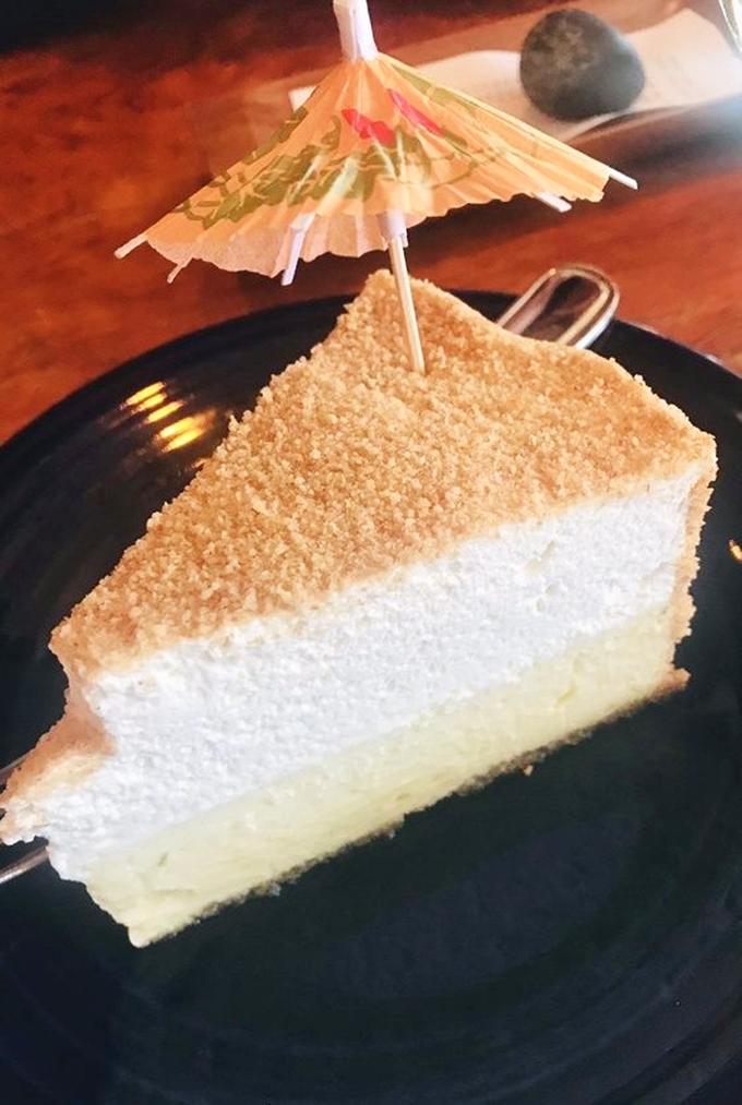 This key lime pie isn't just dessert, it's therapy—with its perfect balance of tart and sweet topped with a tiny umbrella that says "relax, you're on island time now."