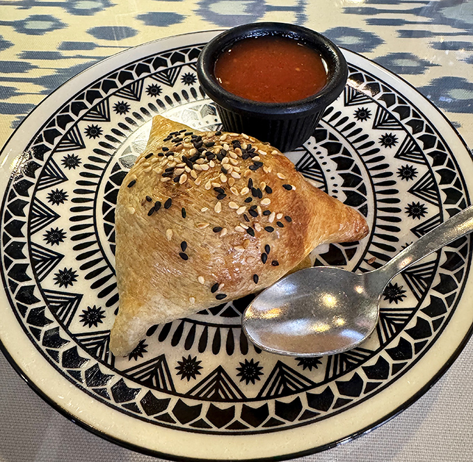 The legendary lamb somsa in all its golden glory. This isn't just pastry&mdash;it's architecture, poetry, and comfort food rolled into one flaky triangle of joy.