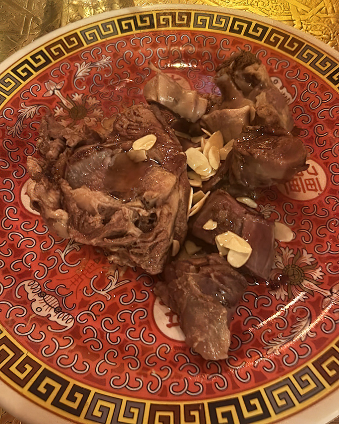 Fall-off-the-bone lamb nestled among slivered almonds tells the story of centuries-old Moroccan cooking techniques where patience transforms humble ingredients into royal feasts.