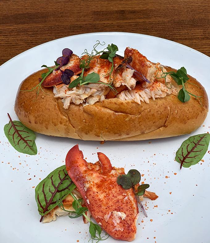 The lobster roll that launched a thousand road trips. Perfectly toasted bun cradling sweet lobster meat, garnished with microgreens &ndash; simplicity that speaks volumes about seafood respect.