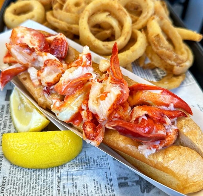 Behold the star attraction &ndash; chunks of sweet lobster meat nestled in a perfectly toasted roll, accompanied by golden onion rings that deserve their own fan club.